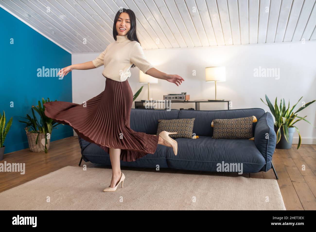 Woman dancing in room looking at camera Stock Photo - Alamy