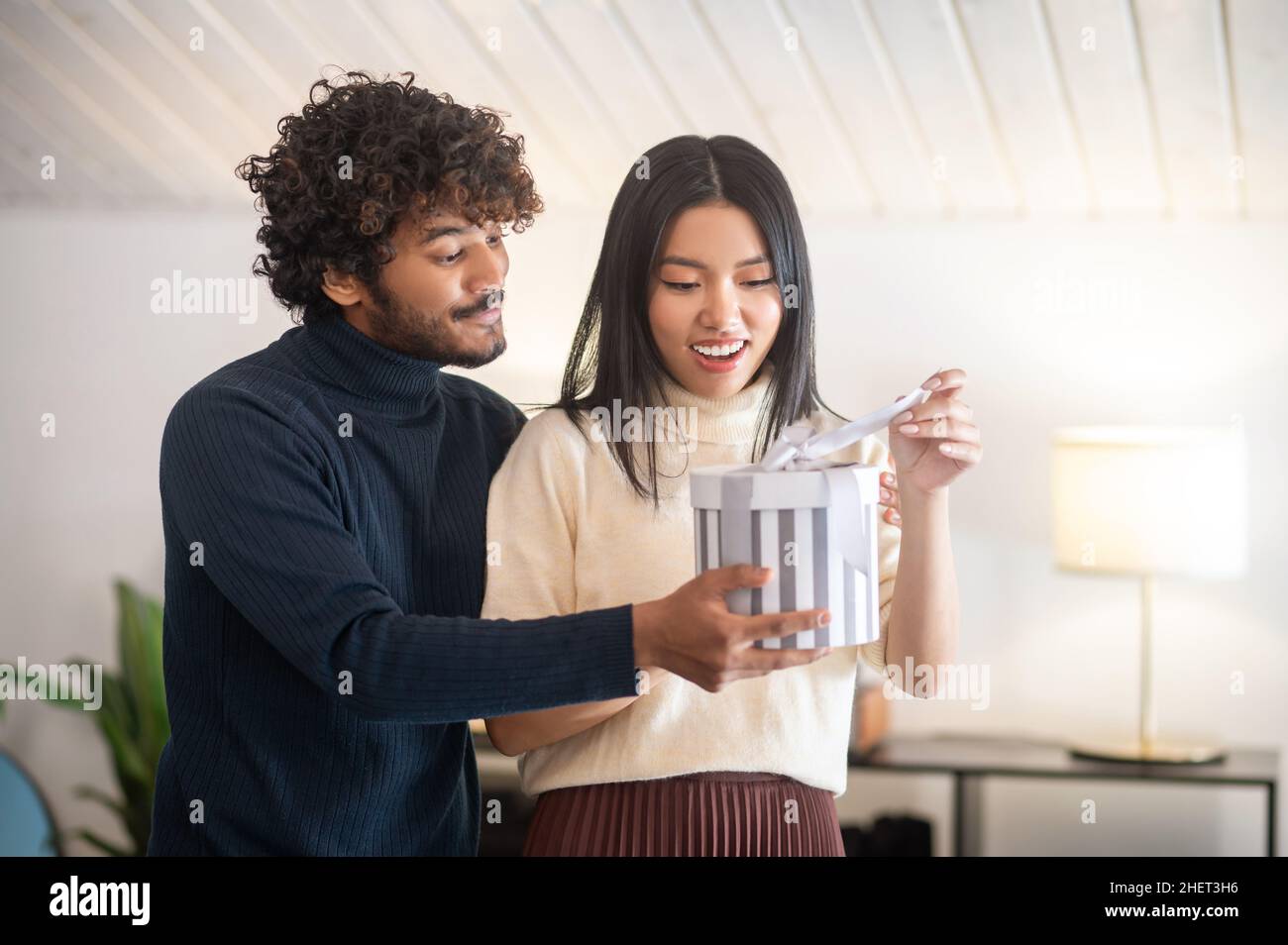 Man giving gift box to surprised woman Stock Photo - Alamy