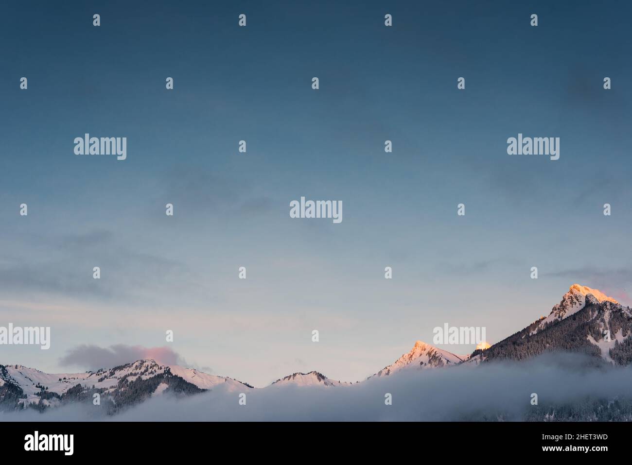 snowy orange peaks of mountain chain in winter with fog Stock Photo - Alamy