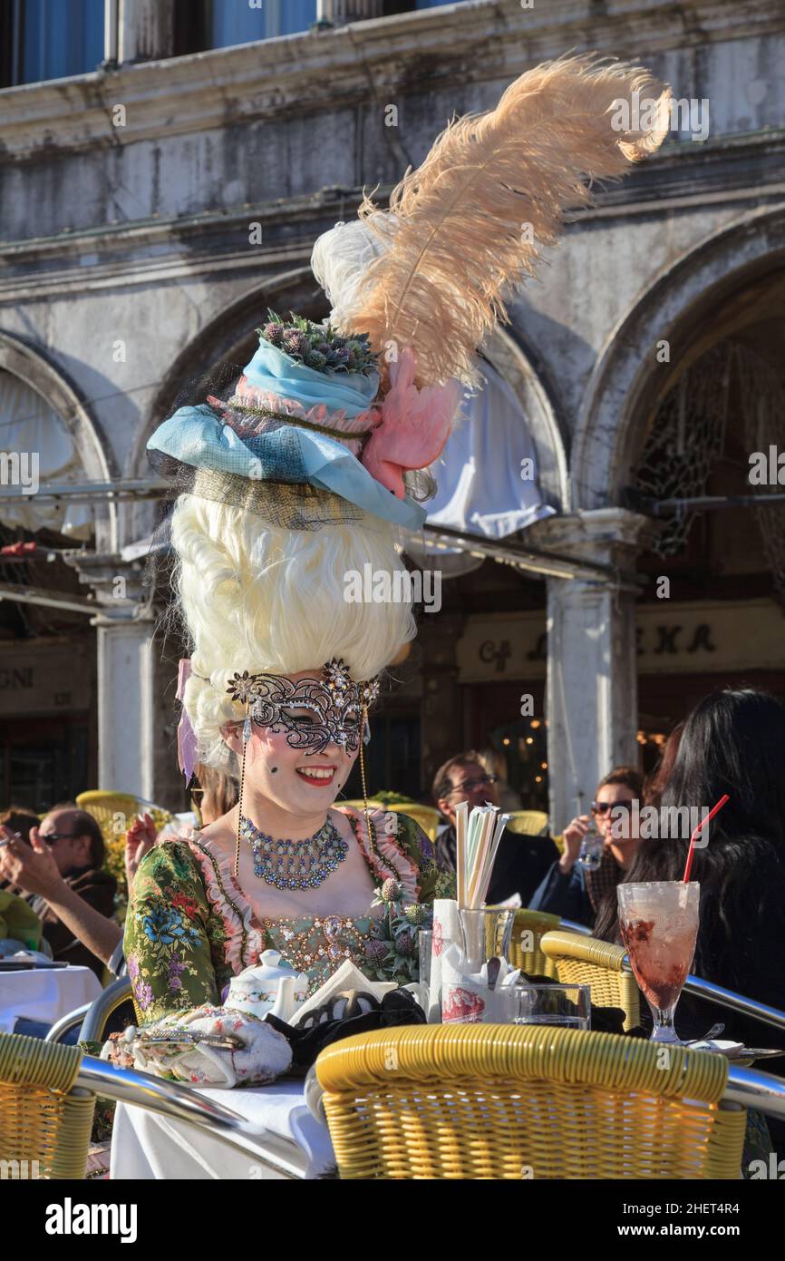 Woman in colourful historic rococo fancy dress costume and hats its in ...