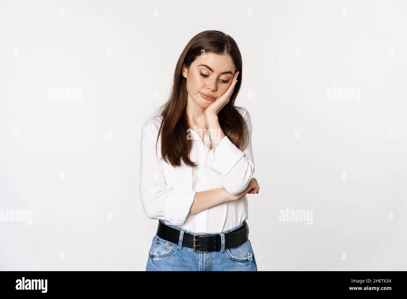 Unamused, bored brunette woman looking gloomy and sad, sighing ...