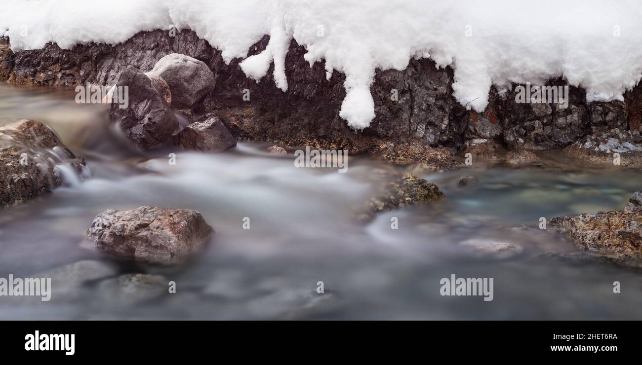 cold water flowing through rocks and stones with snow in winter Stock ...