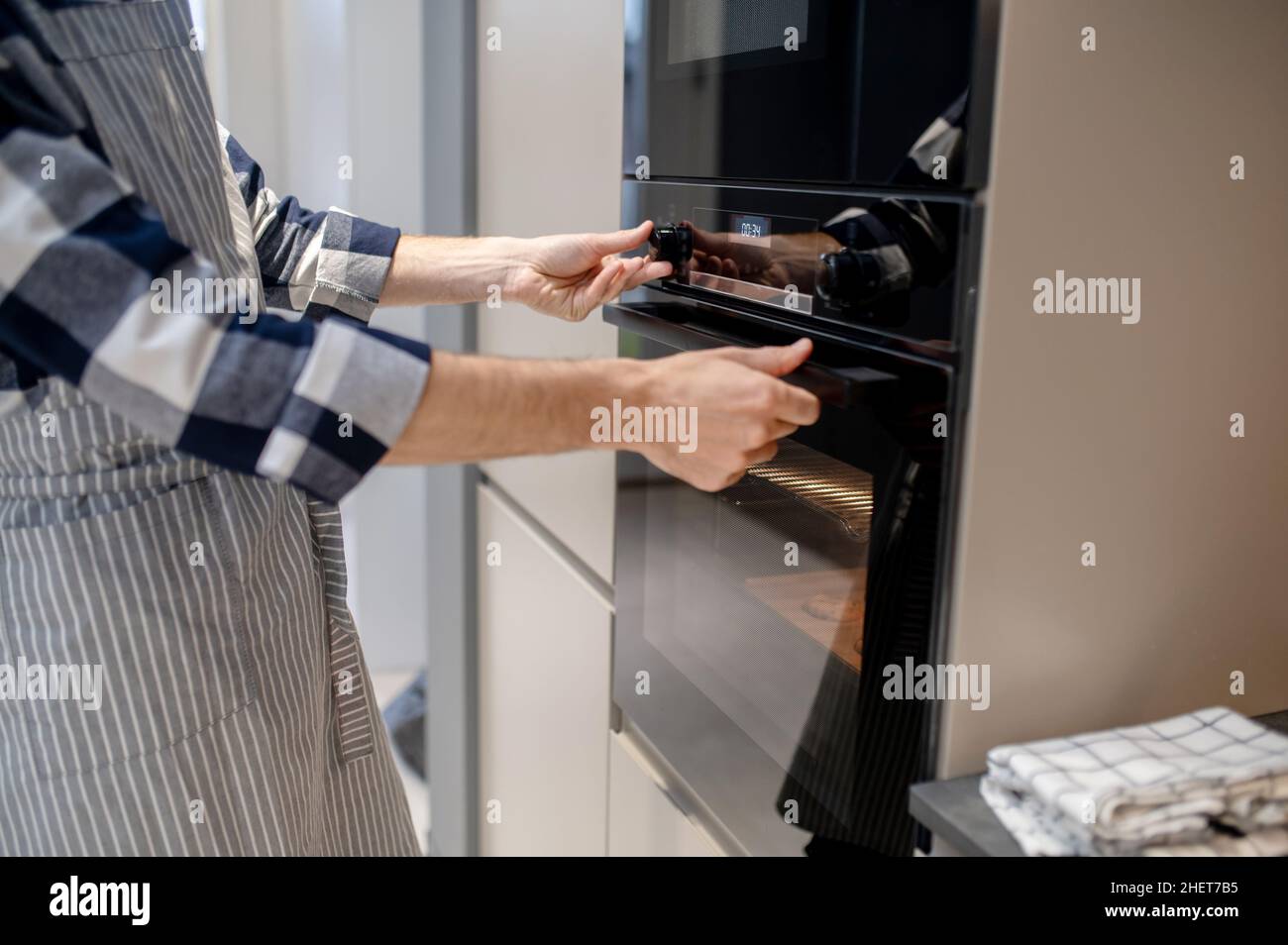 Male hands touching control panel and oven handle Stock Photo - Alamy