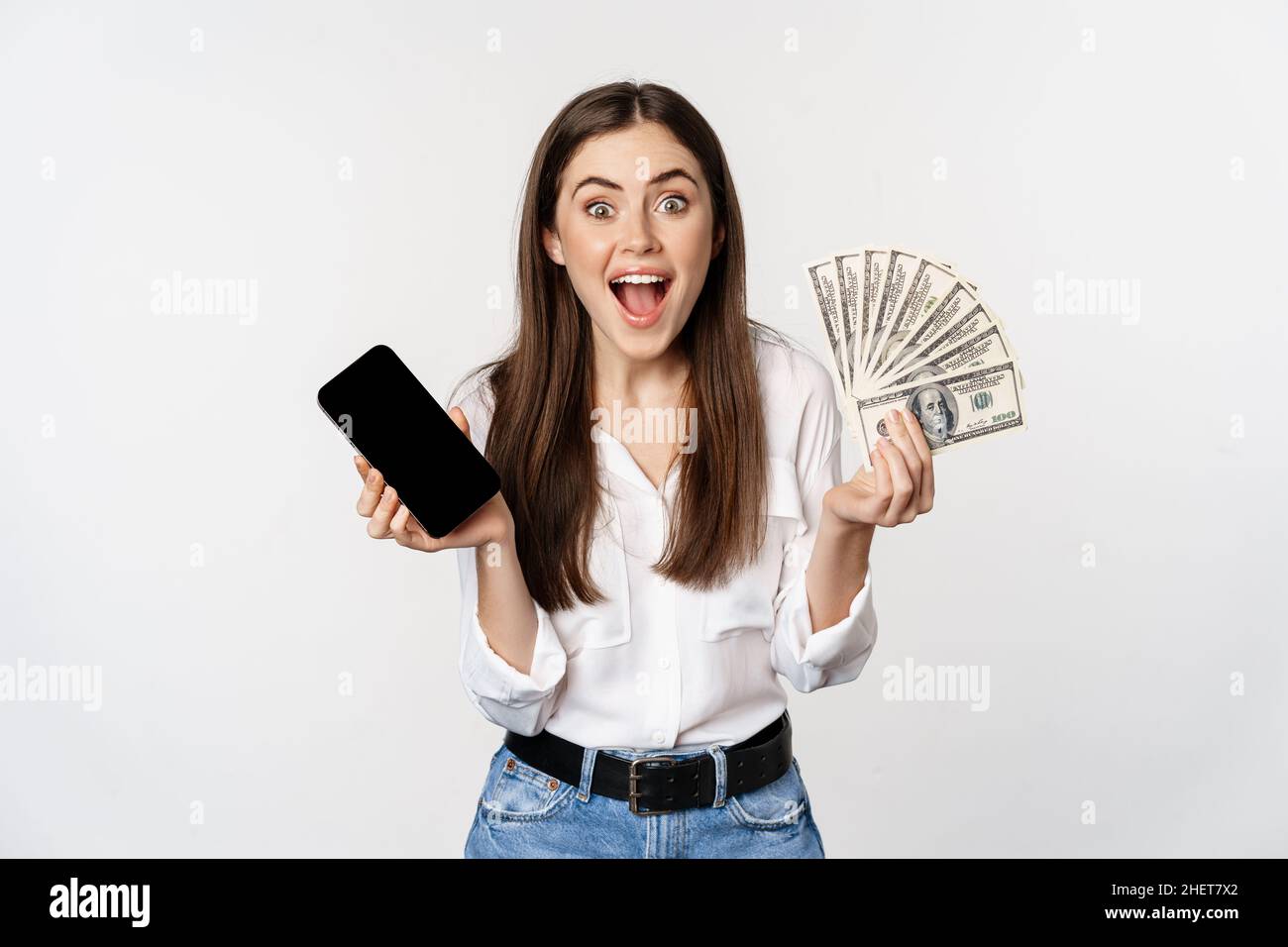 Enthusiastic young woman winning money, showing smartphone app ...