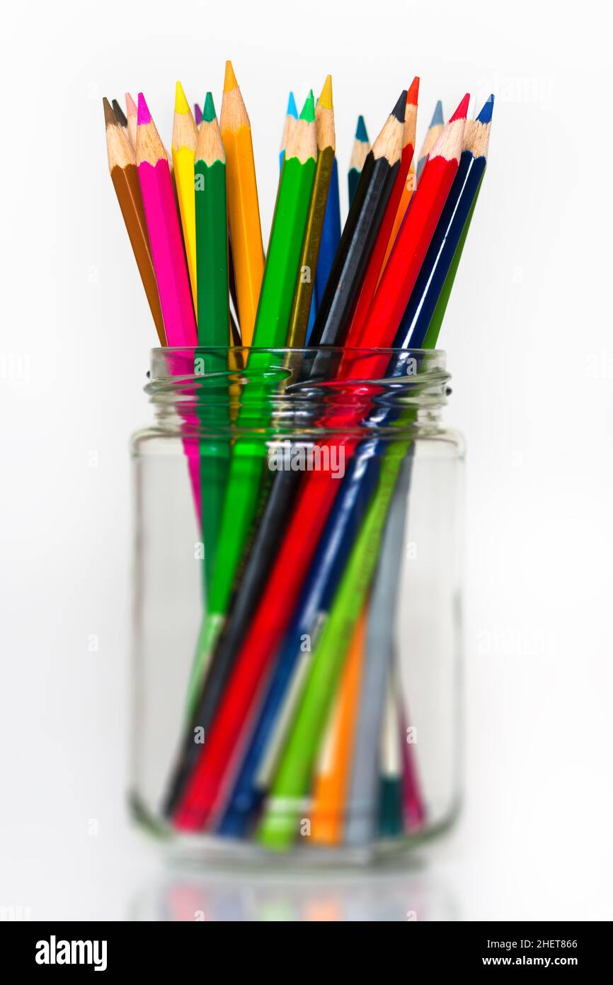 glass full of sharpened wooden color pencils standing on white ...