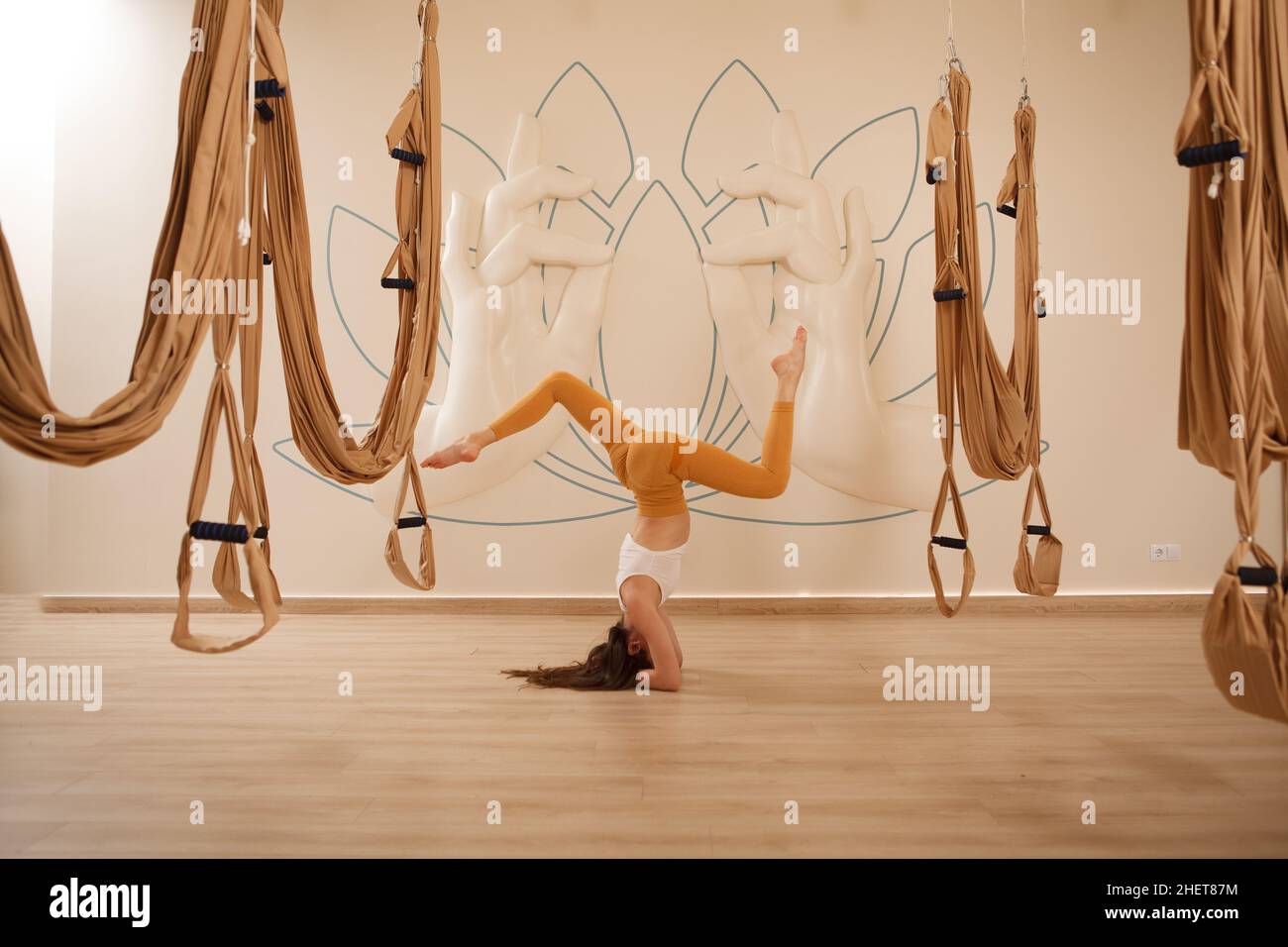 Fit female gymnast doing headstand balancing with bent legs apart Stock ...