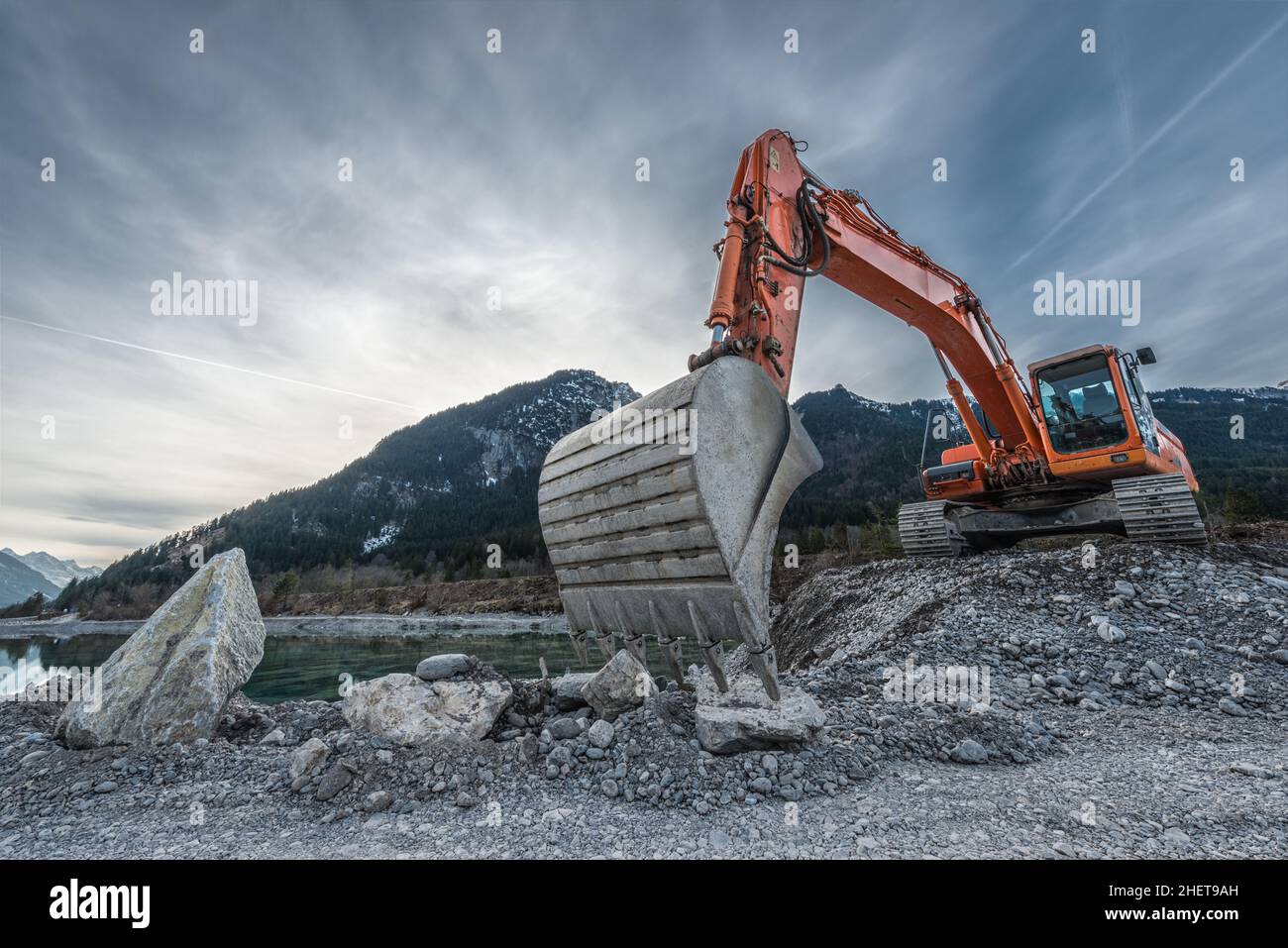 big orange digger on gravel heap with big shovel Stock Photo - Alamy