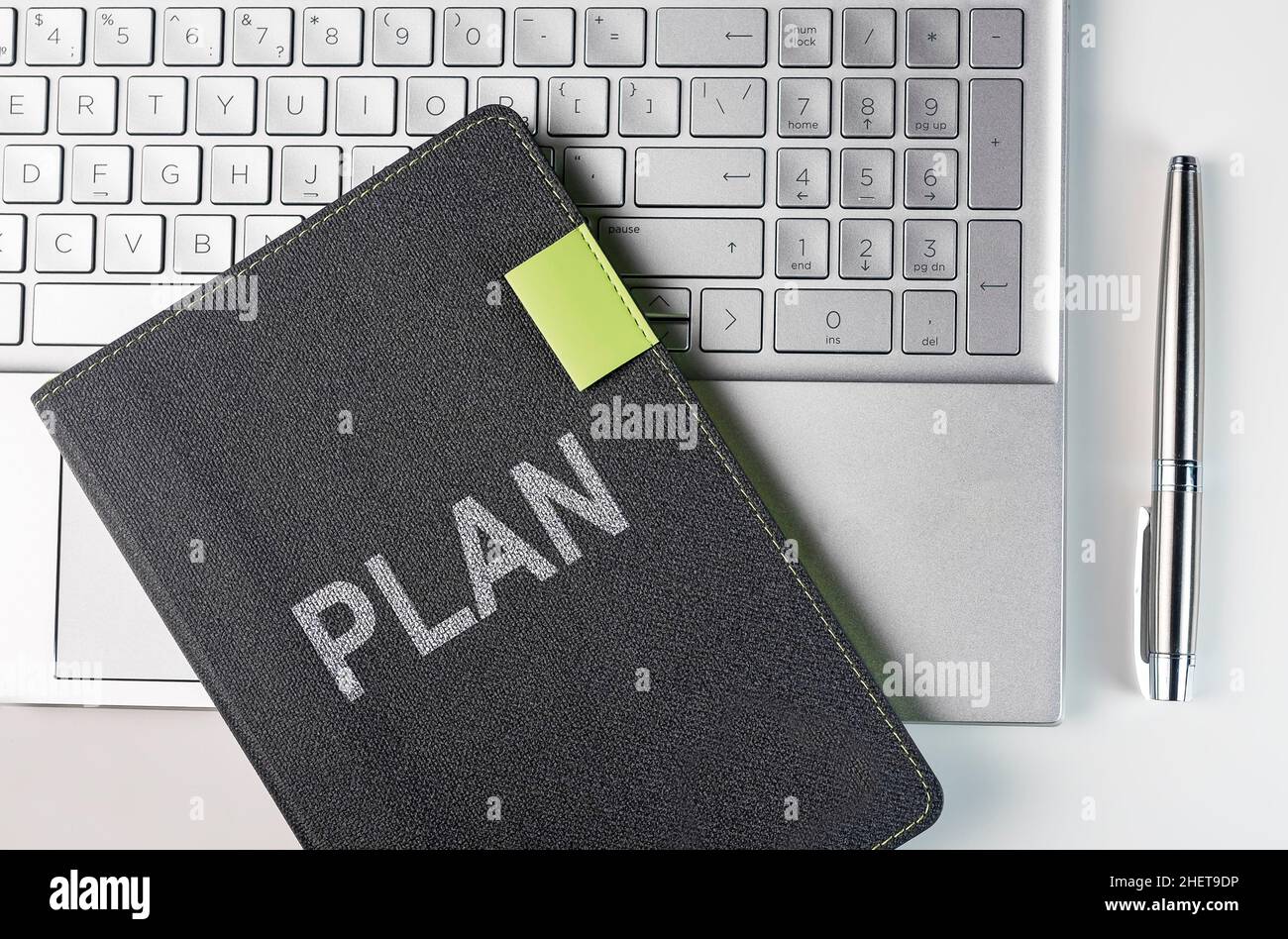 Plan word on business planner notebook on laptop keyboard and pen of ...