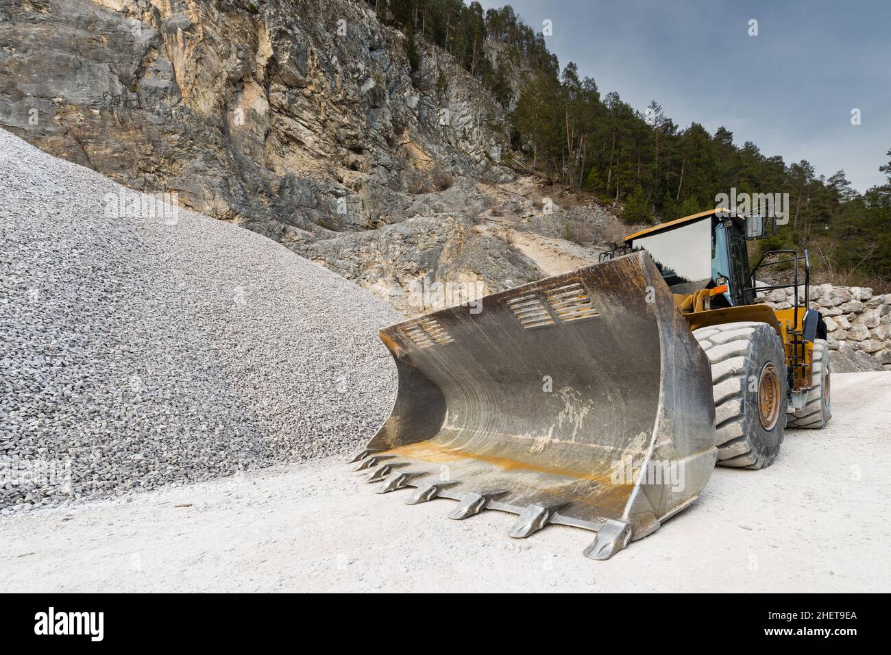 huge shovel of wheel loader at stone quarry with gravel hill Stock ...