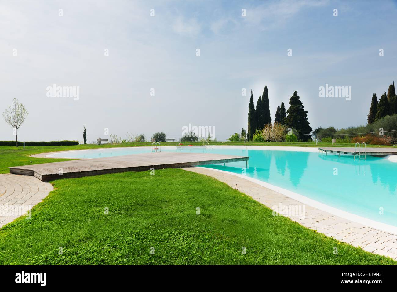 cyan blue water pool next grass meadow with boardwalk Stock Photo - Alamy