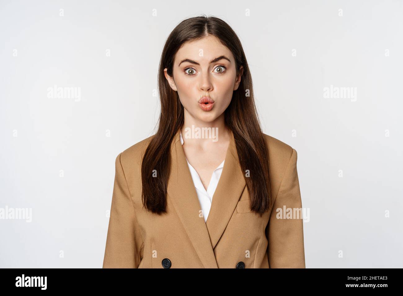 Portrait of office lady at workplace, looking surprised and curious ...