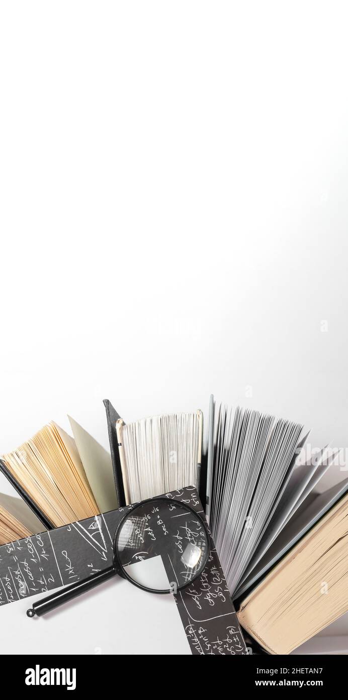 Magnifying lens over books and copy space for text on vertical ...