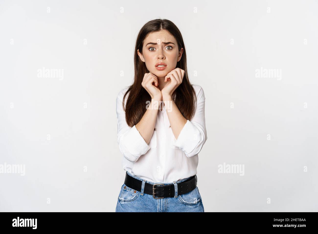 Portrait of brunette woman looking concerned, worried and shocked ...