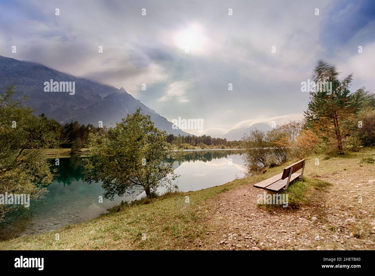 wooden bench at lake with bushes and trees in fall Stock Photo - Alamy