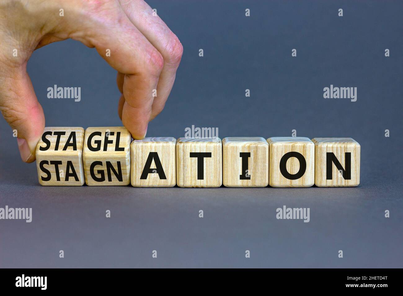 Stagflation or stagnation symbol. Businessman turns cubes, changes the ...
