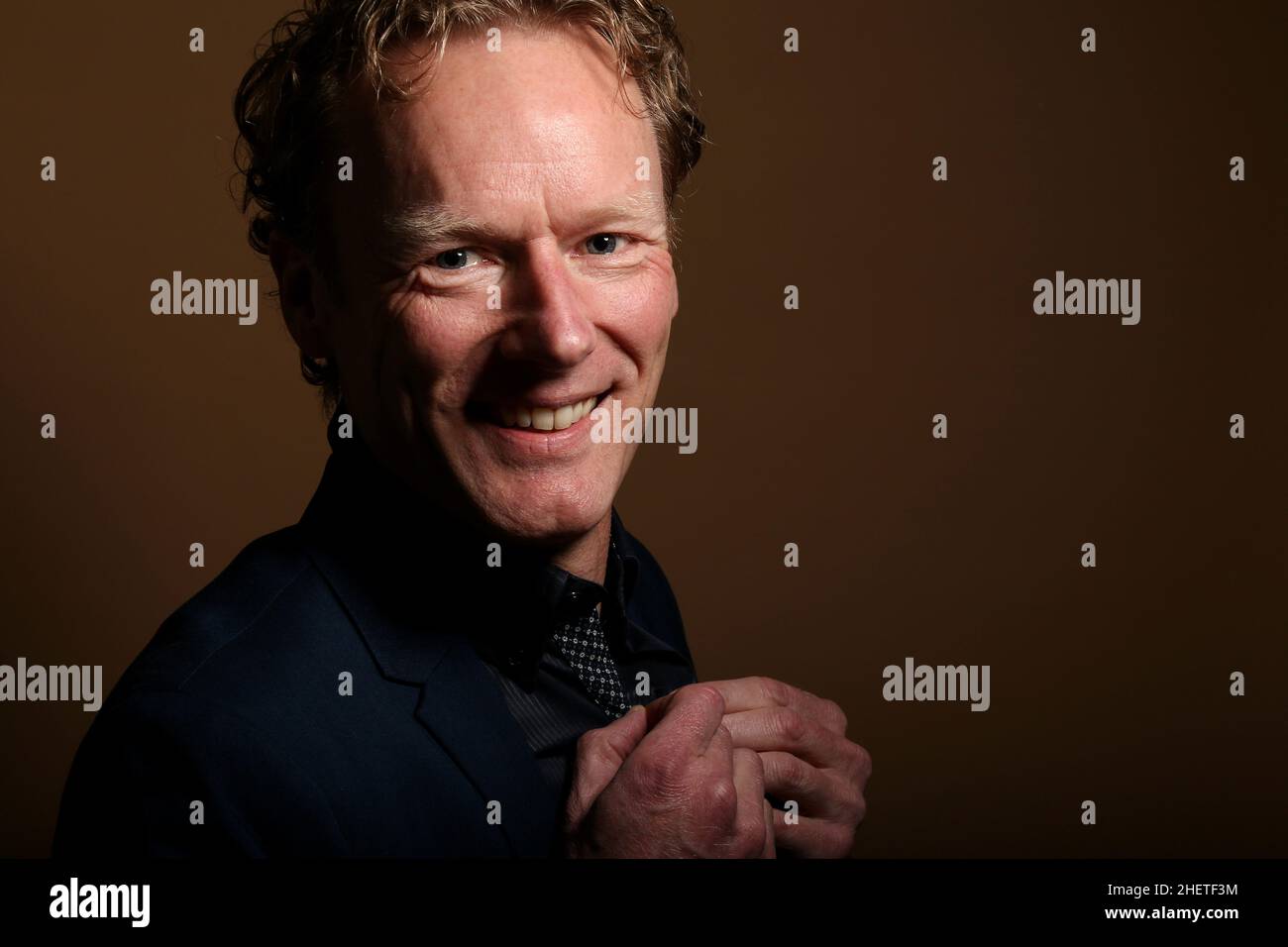 Portrait of a beautiful happy man in front of a colored background ...