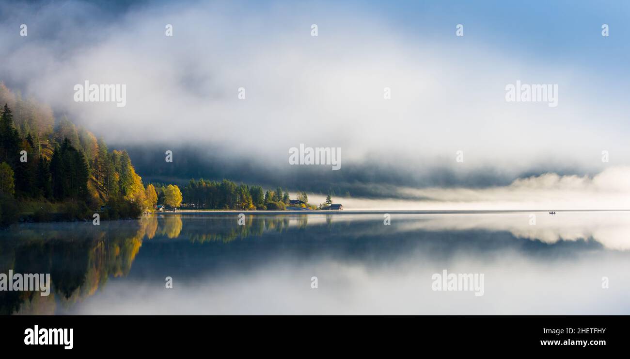 idyllic fall mood at tyrol lake with morning dust and colored forest ...