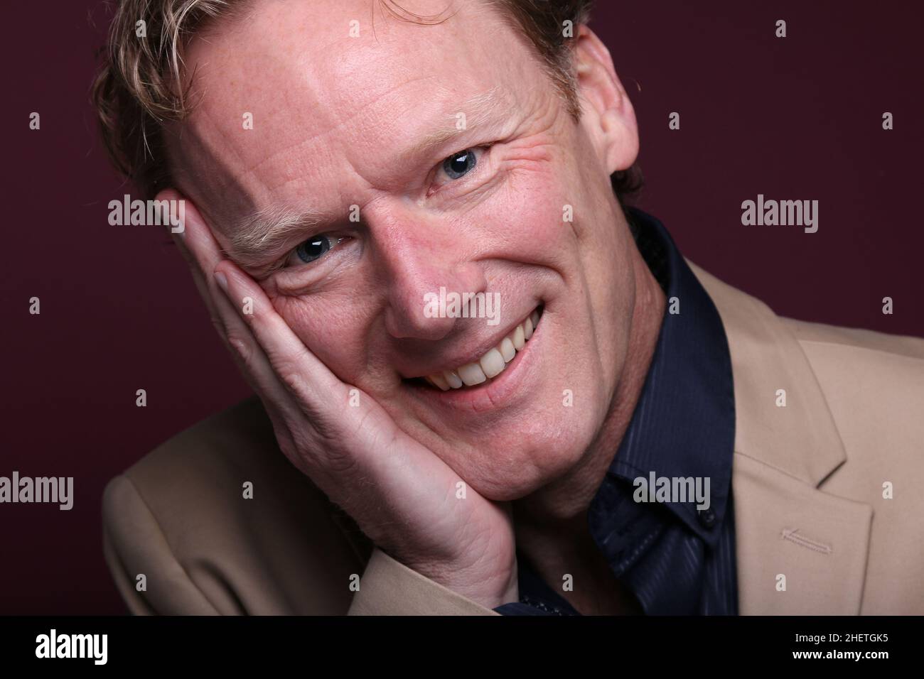 Portrait of a beautiful happy man in front of a colored background ...