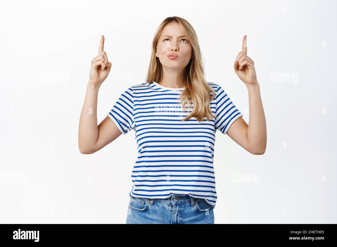 Confused and perplexed young woman deciding, frowning and pointing ...
