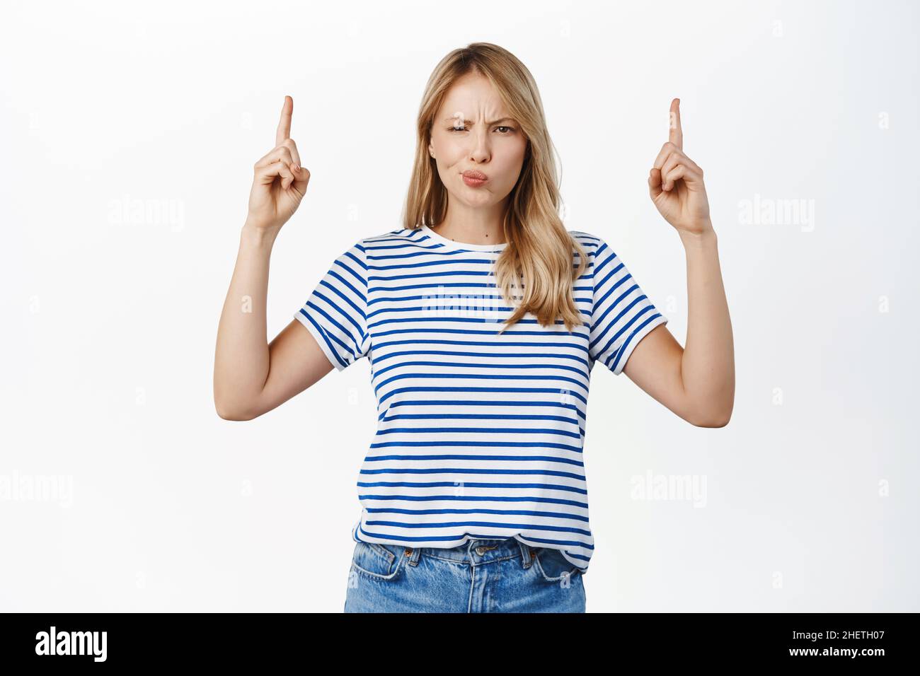 Confused and perplexed young woman deciding, frowning and pointing ...