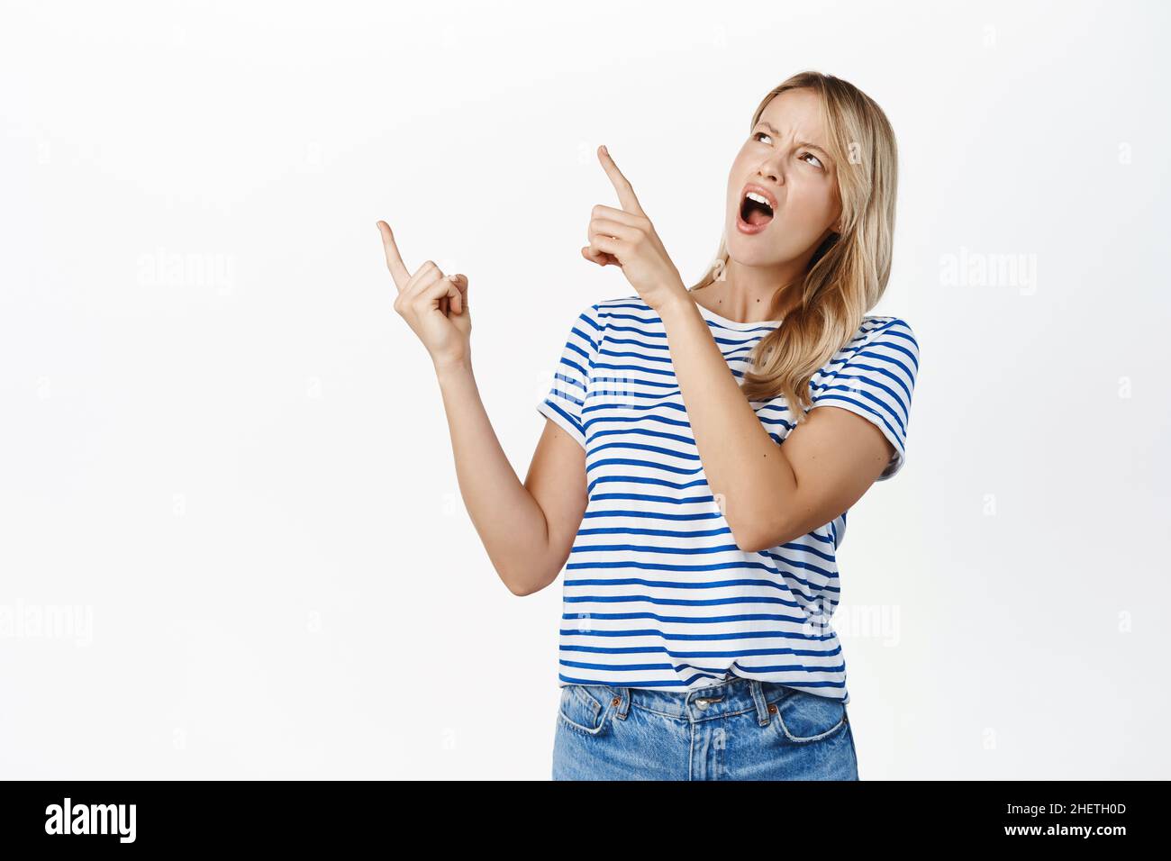 Frustrated young stylish girl pointing left and complaining, looking ...