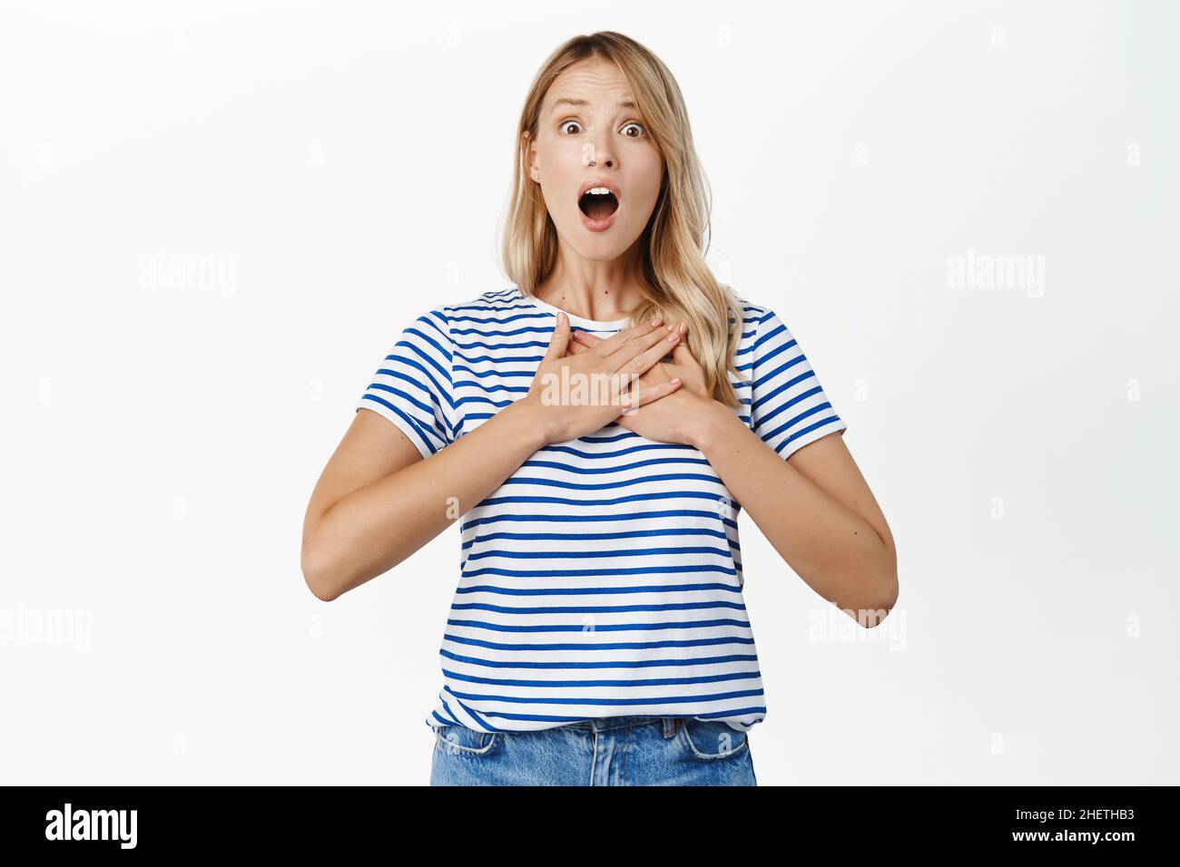 Shocked girl screams and looks startled, holds hands on heart, jumping ...