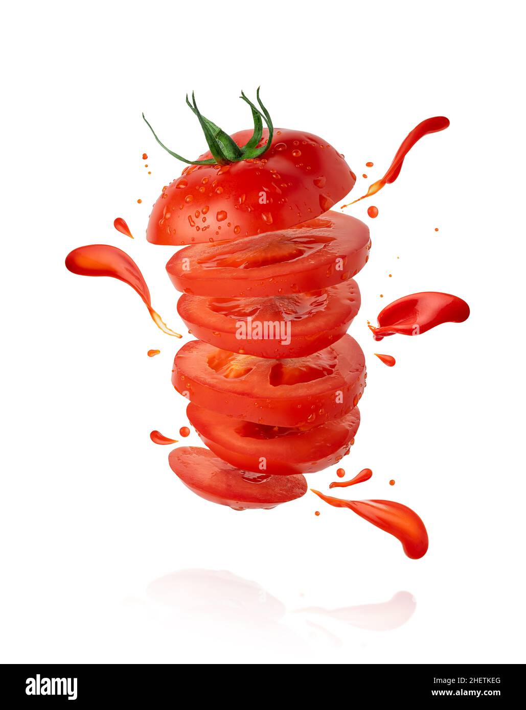 Flying sliced tomato with flowing splashes of ketchup isolated on white ...