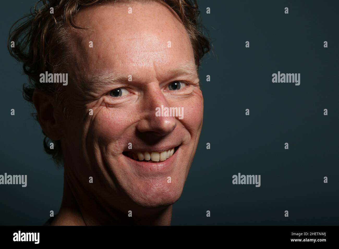 Portrait of a beautiful happy man in front of a colored background ...
