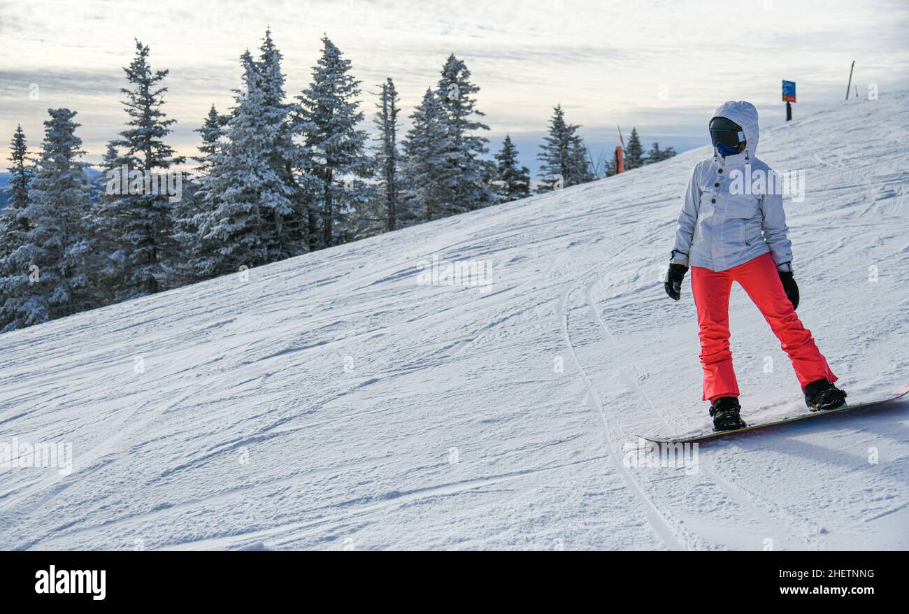 Female snowboarder running down the slope in Stowe Mountain Resort ...