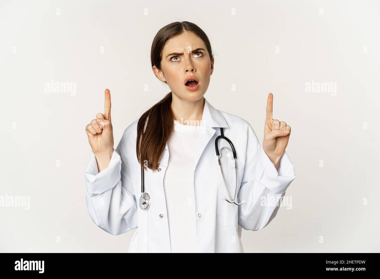 Sad and disappointed female doctor, frowning frustrated, pointing ...