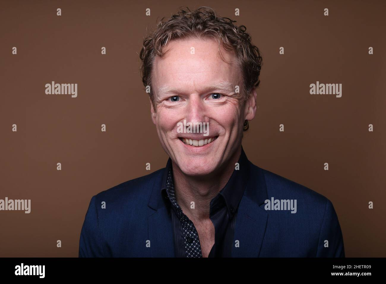 Portrait of a beautiful happy man in front of a colored background ...
