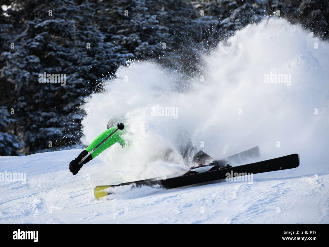 Male skier in bright outfit skiing downhill on fresh powder snow ...