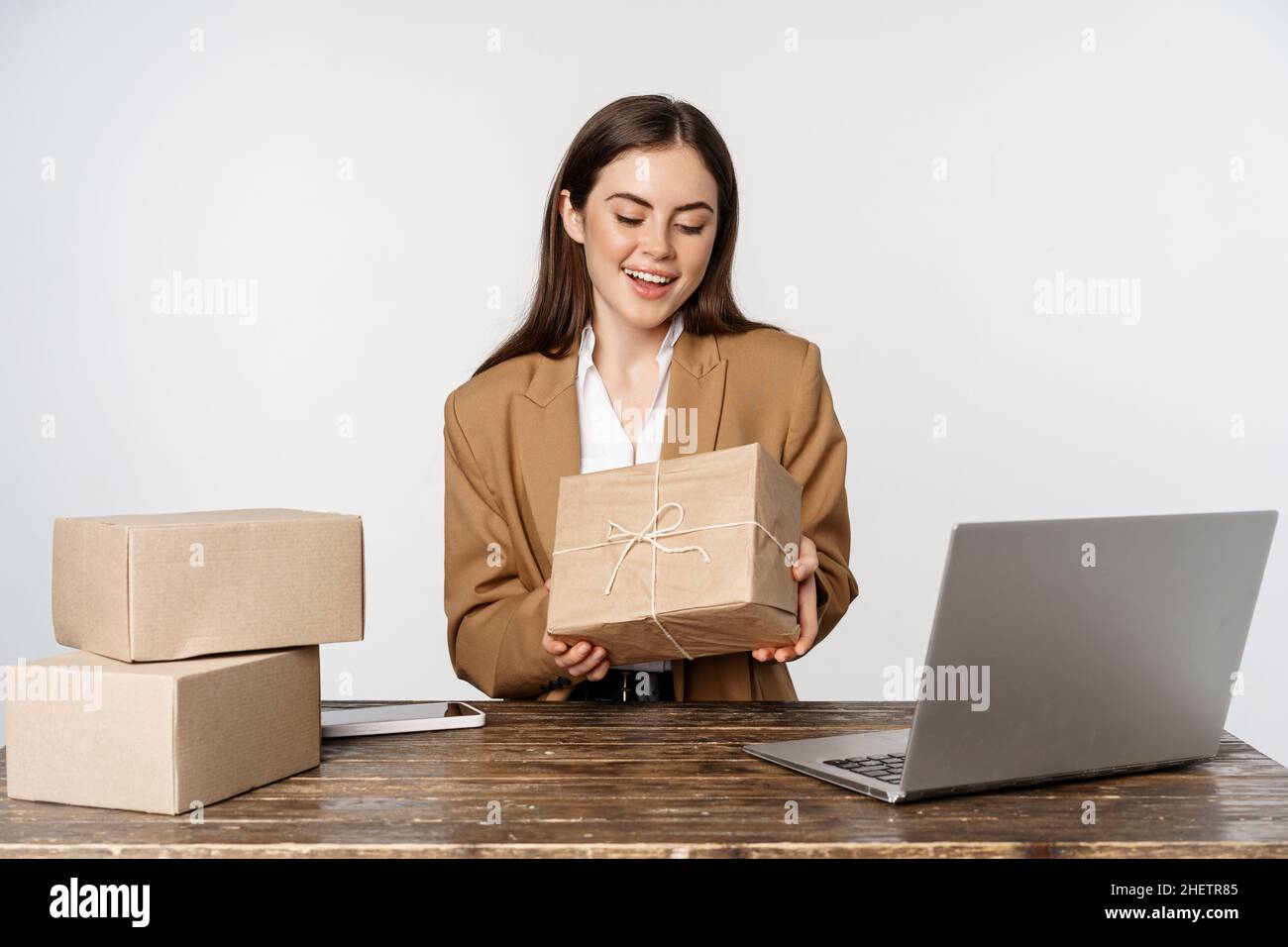 Businesswoman, store owner sitting near laptop, holding box with client ...