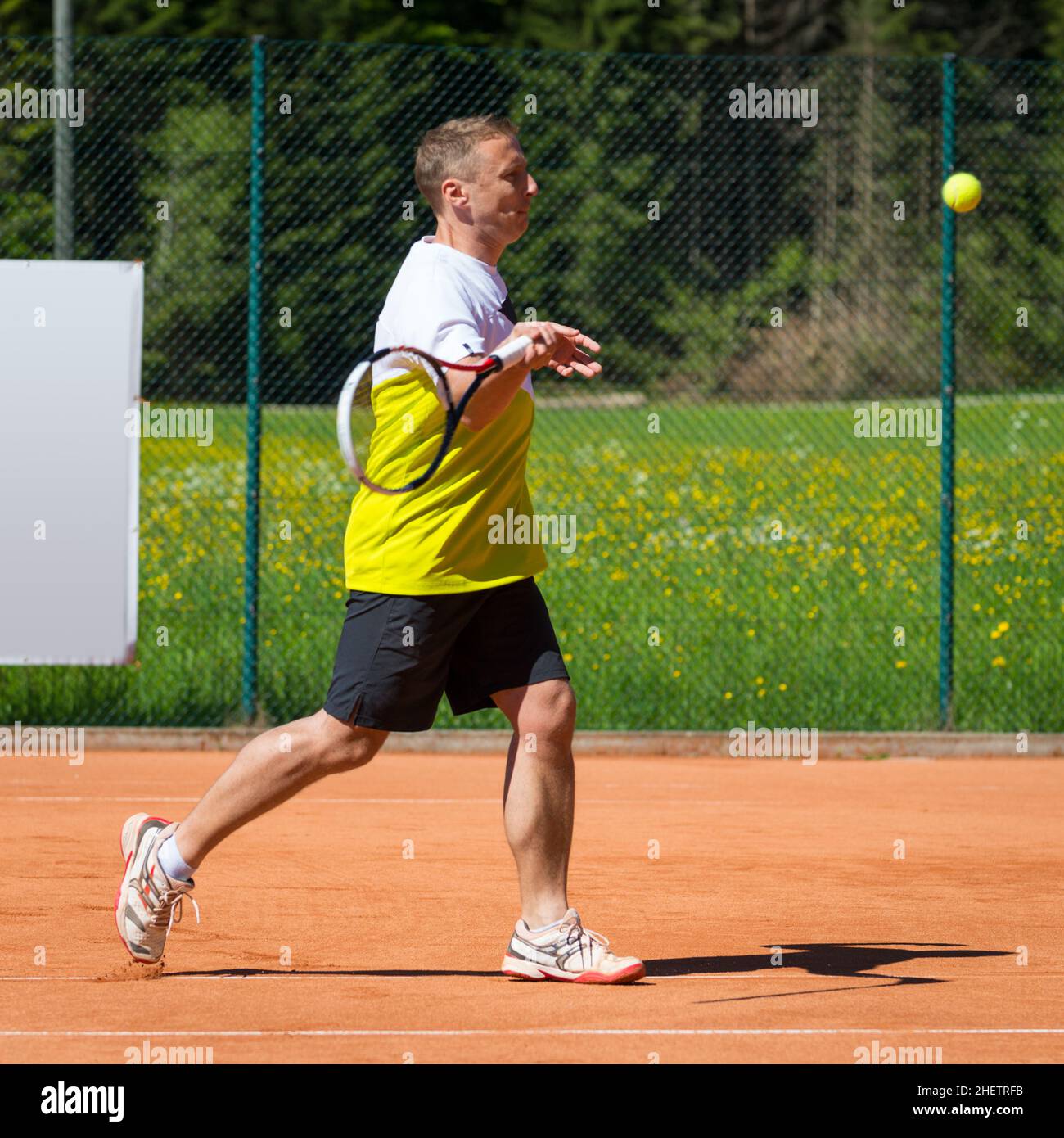side view of tennis player hitting a forehand Stock Photo - Alamy
