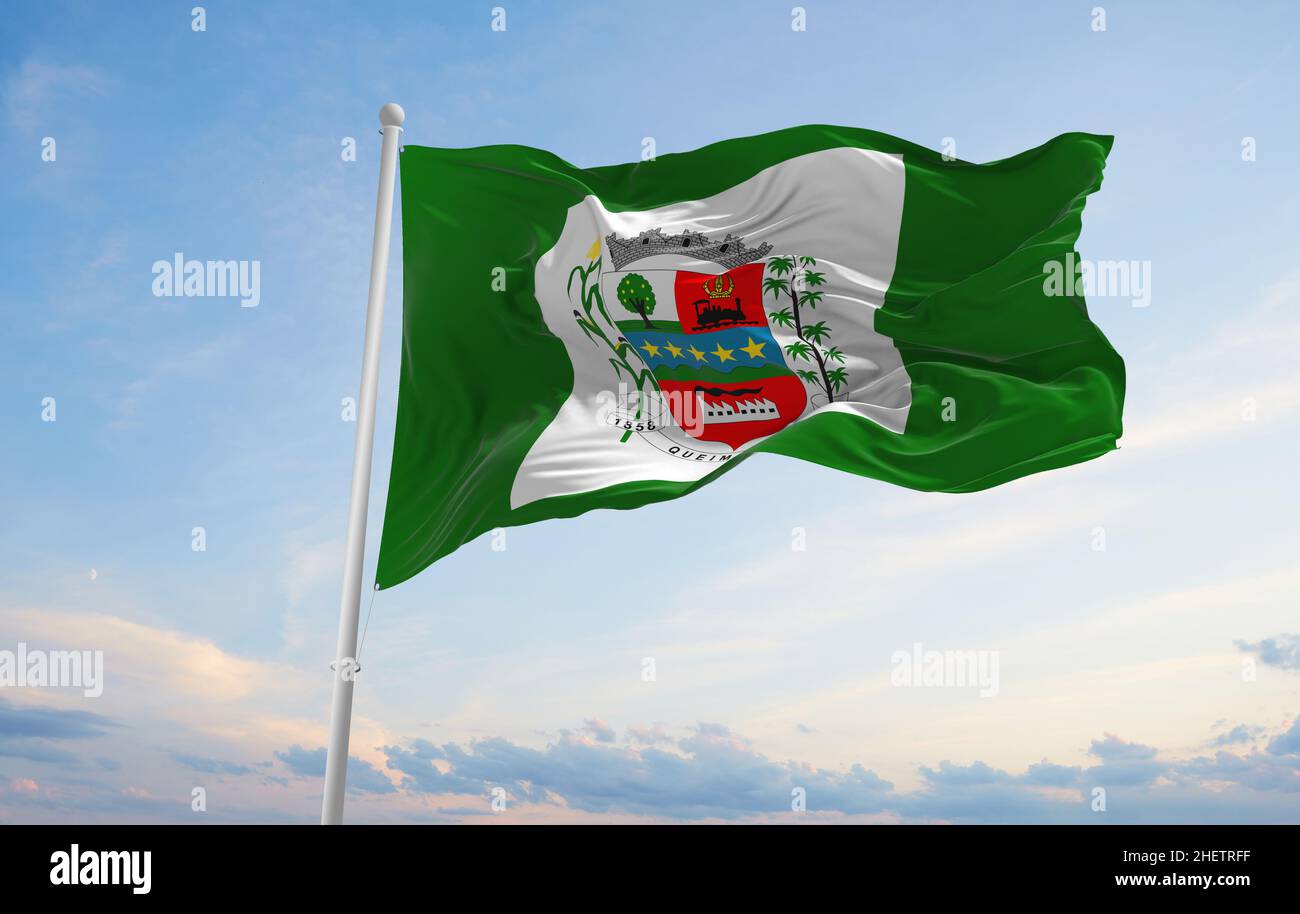 flag of Queimados , Brazil at cloudy sky background on sunset ...