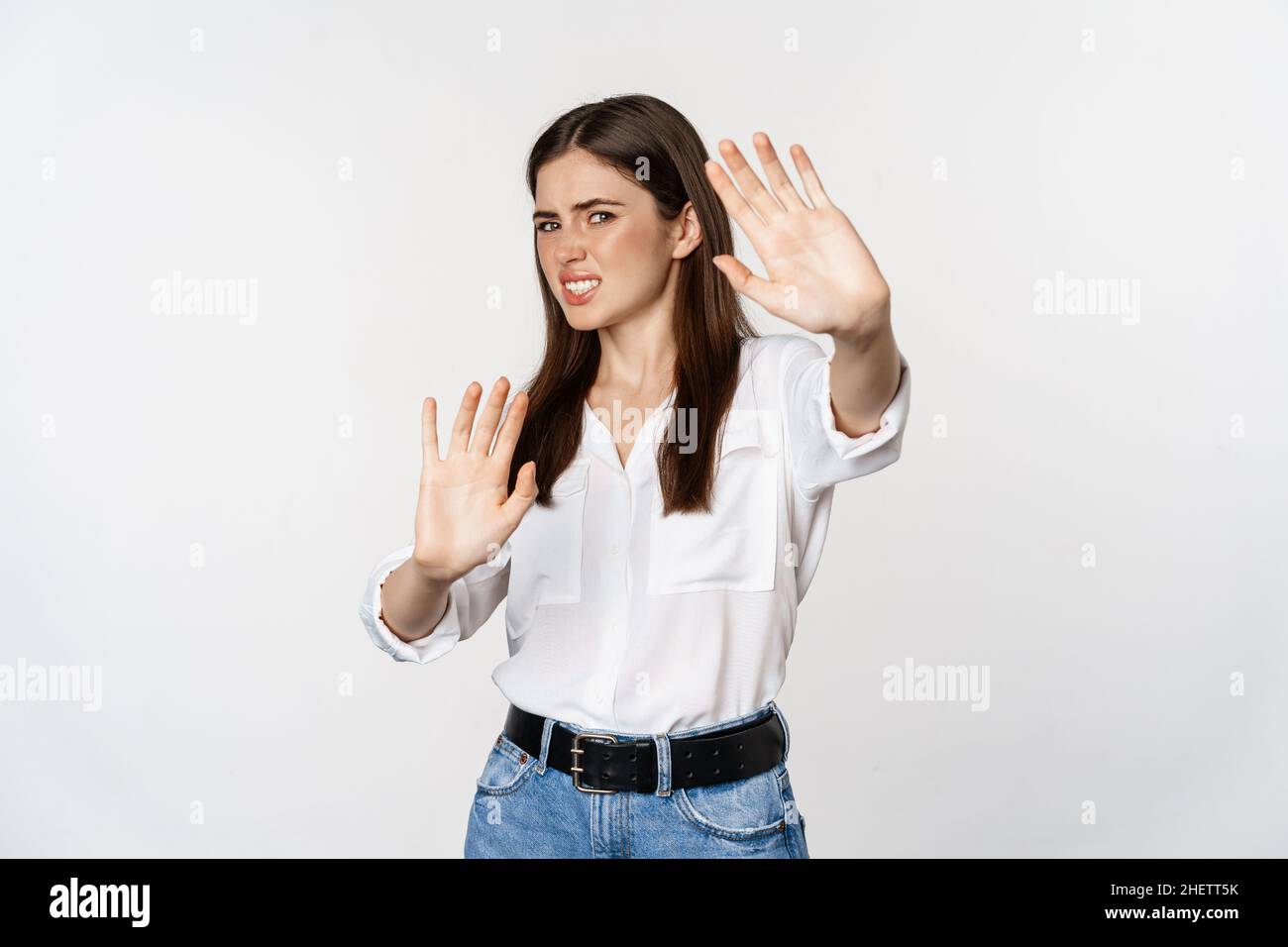 Displeased woman showing stop, rejection gesture, waving hands to ...