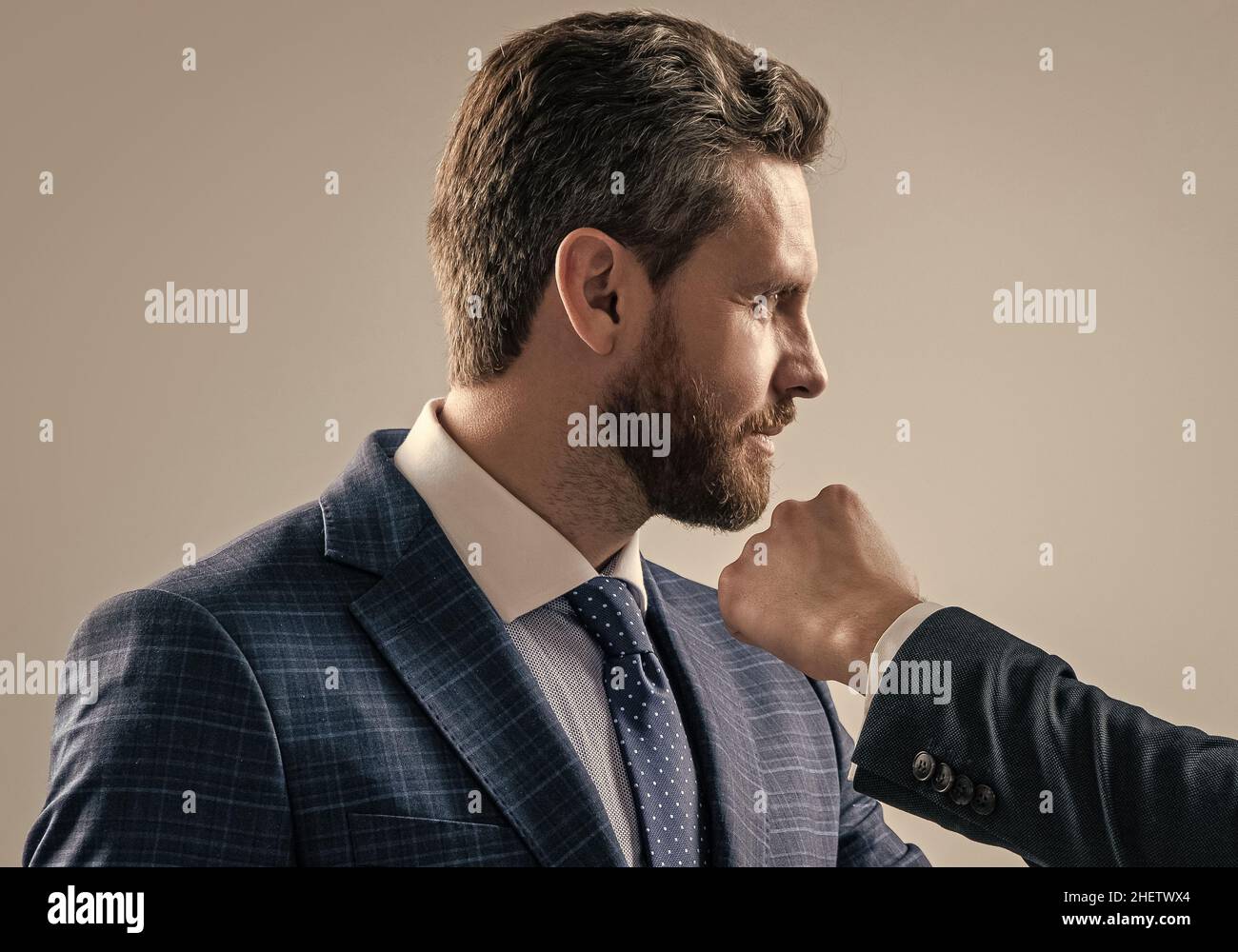 Professional man manager taking male fist punch in face grey background ...