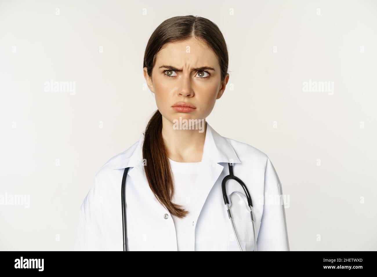 Angry and upset young woman doctor, female healthcare worker sulking ...