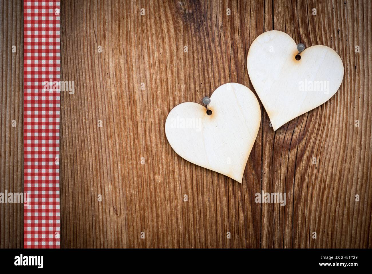 two wooden hearts on sun burned wood plank with ribbon Stock Photo - Alamy