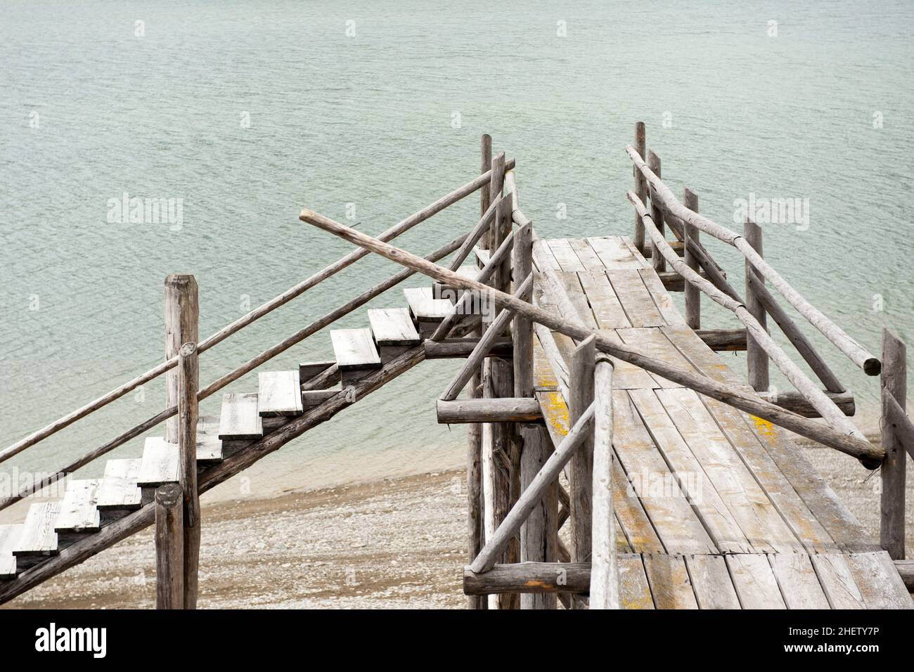 blocked obsolete wooden catwalk bridge at lake with less water and ...