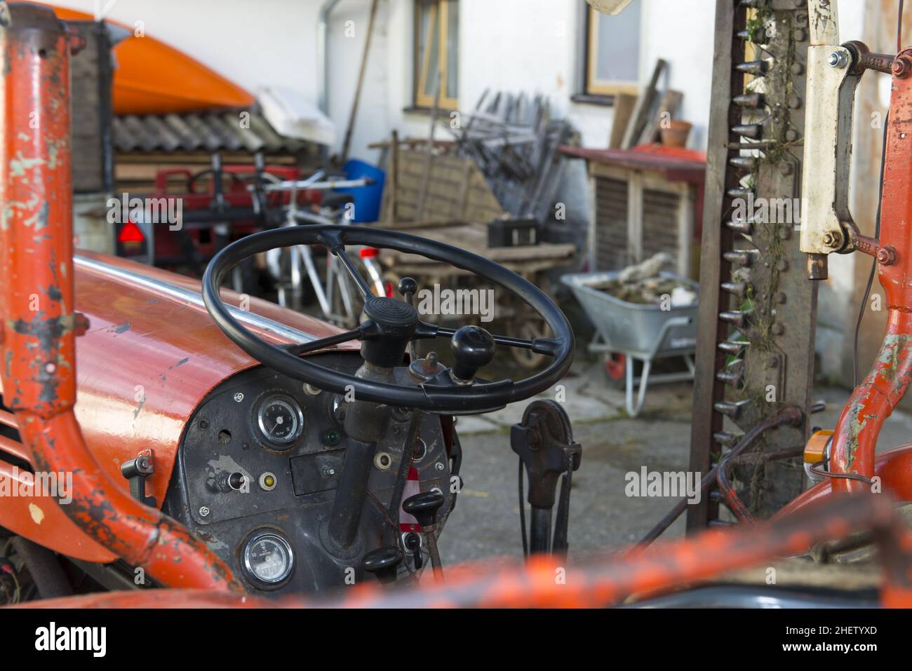 view into cockpit of old red tractor with big steering wheel Stock ...