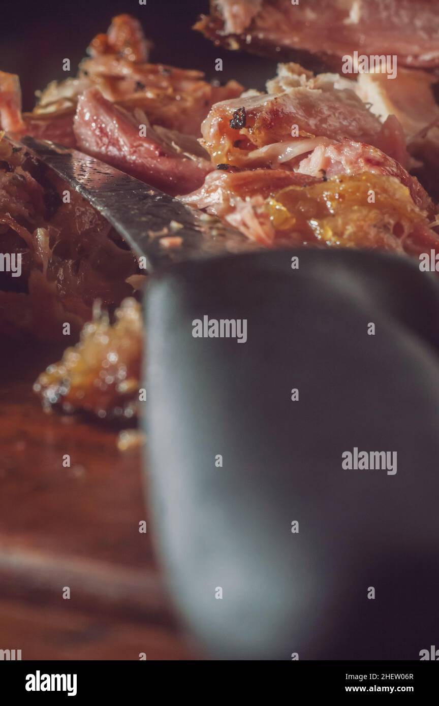 pig's knee on a wooden board with copy space and heat blower plucking ...