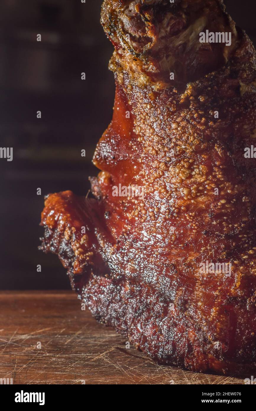 pig's knee on a wooden board with copy space and heat blower plucking ...