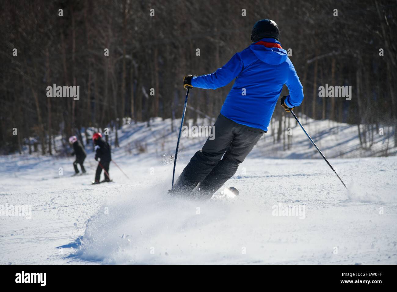 Back view of the male skier downhill on a fresh powder snow Stock Photo ...