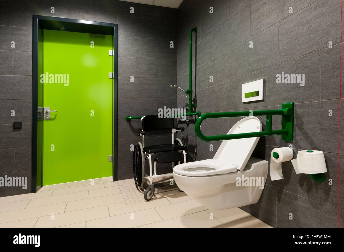 a toilet for disabled people with green bars, wheelchair and door Stock ...