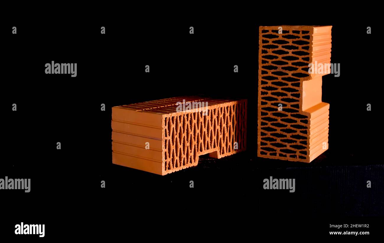 Close up of orange perforated bricks with round holes moving isolated ...