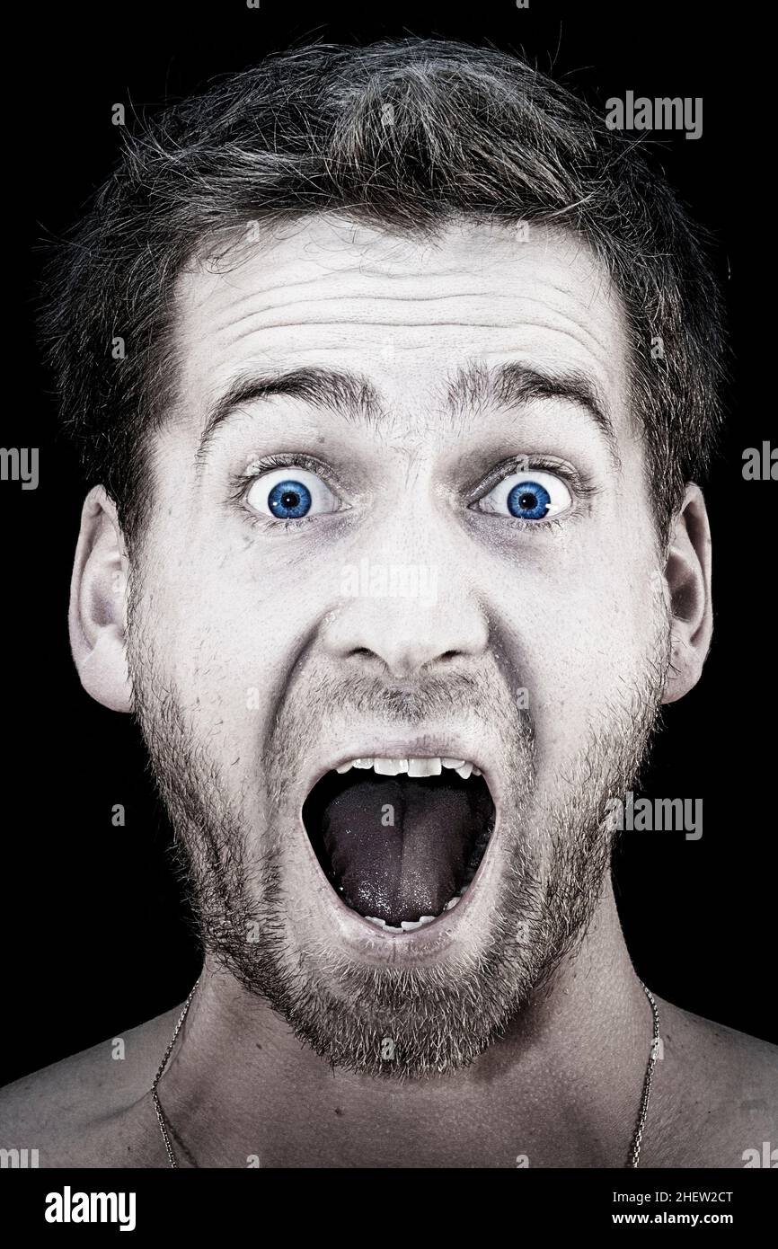 portrait of a young blue eyed men with three-day beard, who's shouting ...