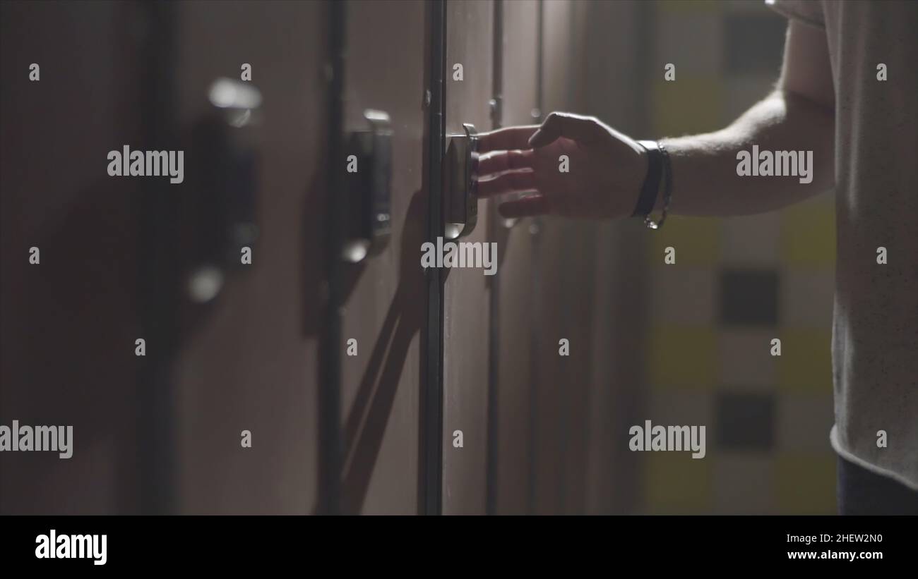 Man's hand opening locker with electric key on his wrist at gym in the ...