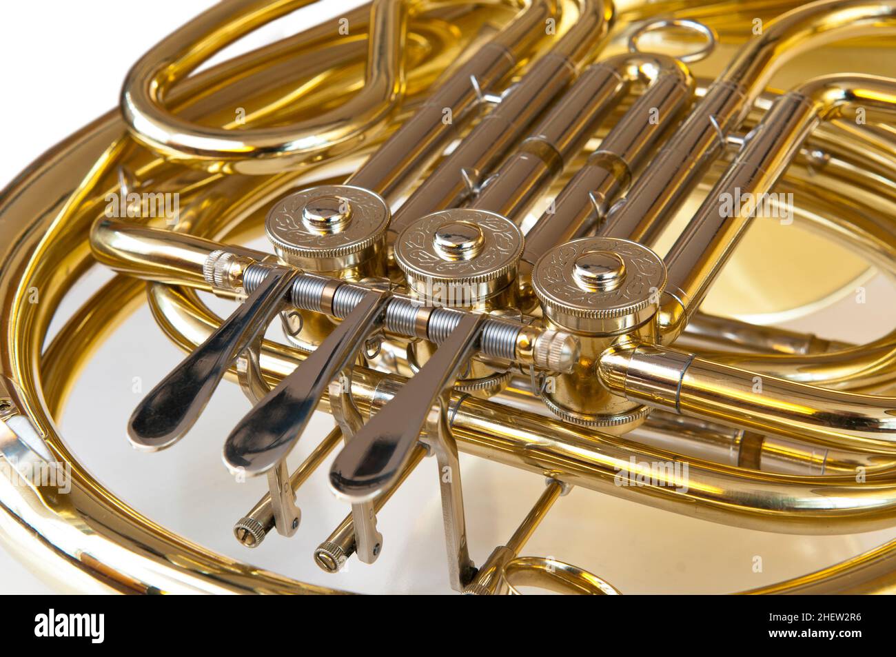 detail of brass and silver horn or bugle with valves lying on a white ...