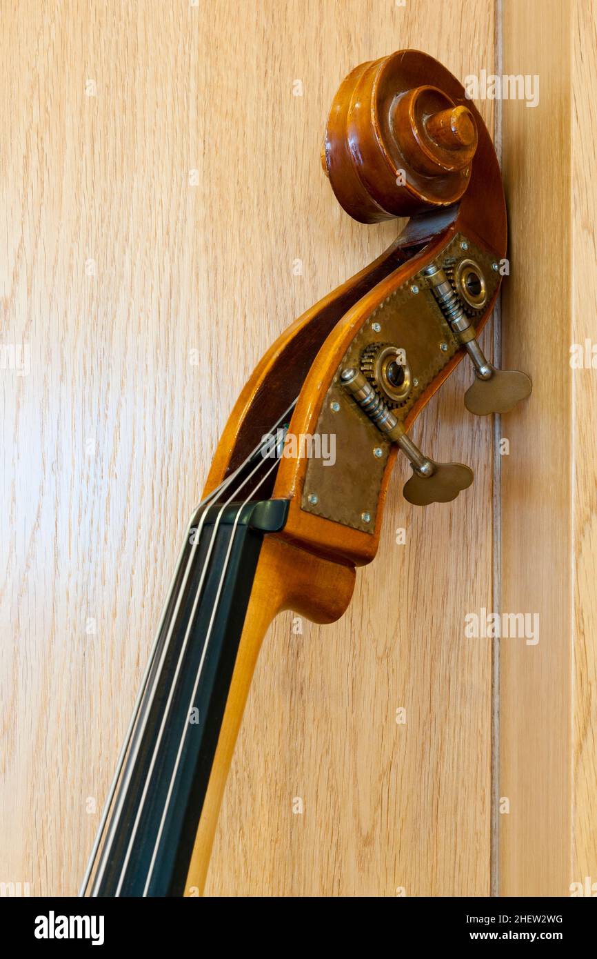 the top of a cello neck leans on a wooden wall Stock Photo - Alamy